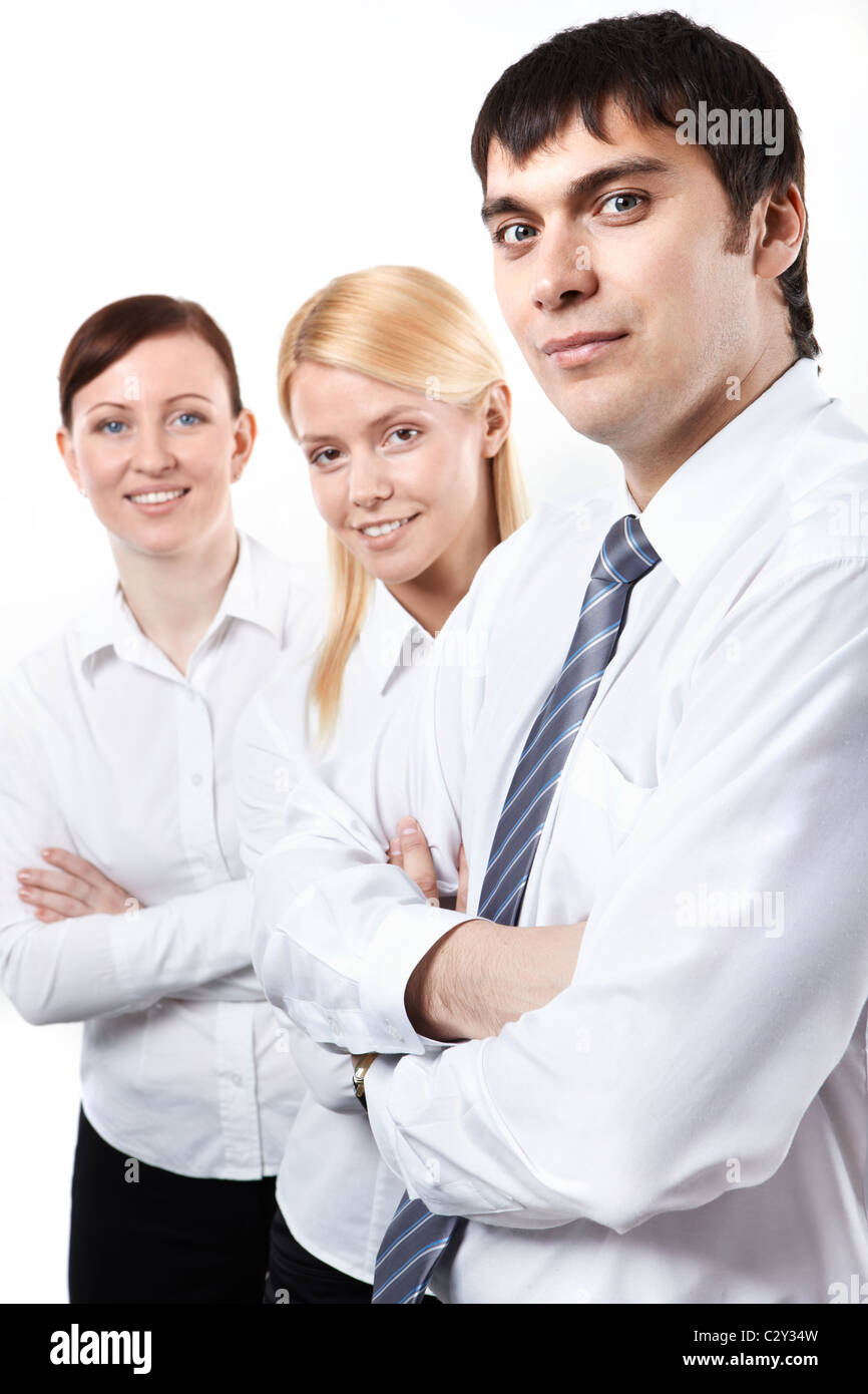 A young manager standing by his two female colleagues and looking at ...