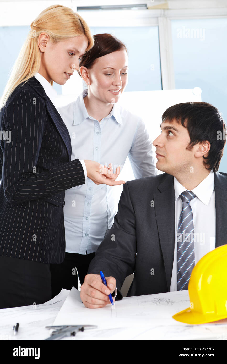Two businesswomen asking a businessman about his plan Stock Photo - Alamy