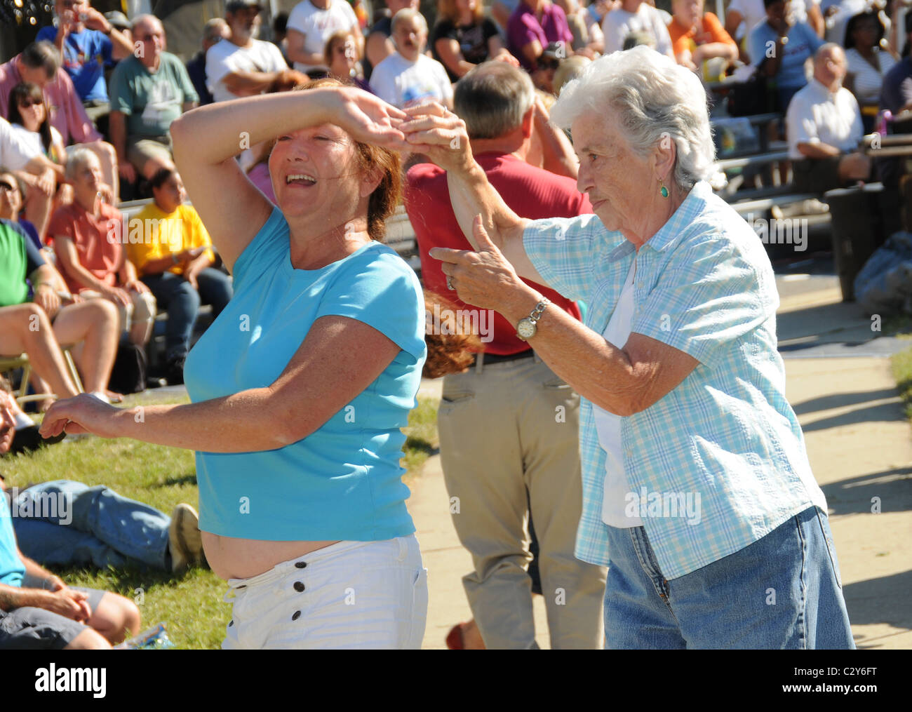 Older woman dancing with a senior woman at a outdoor concert in ...