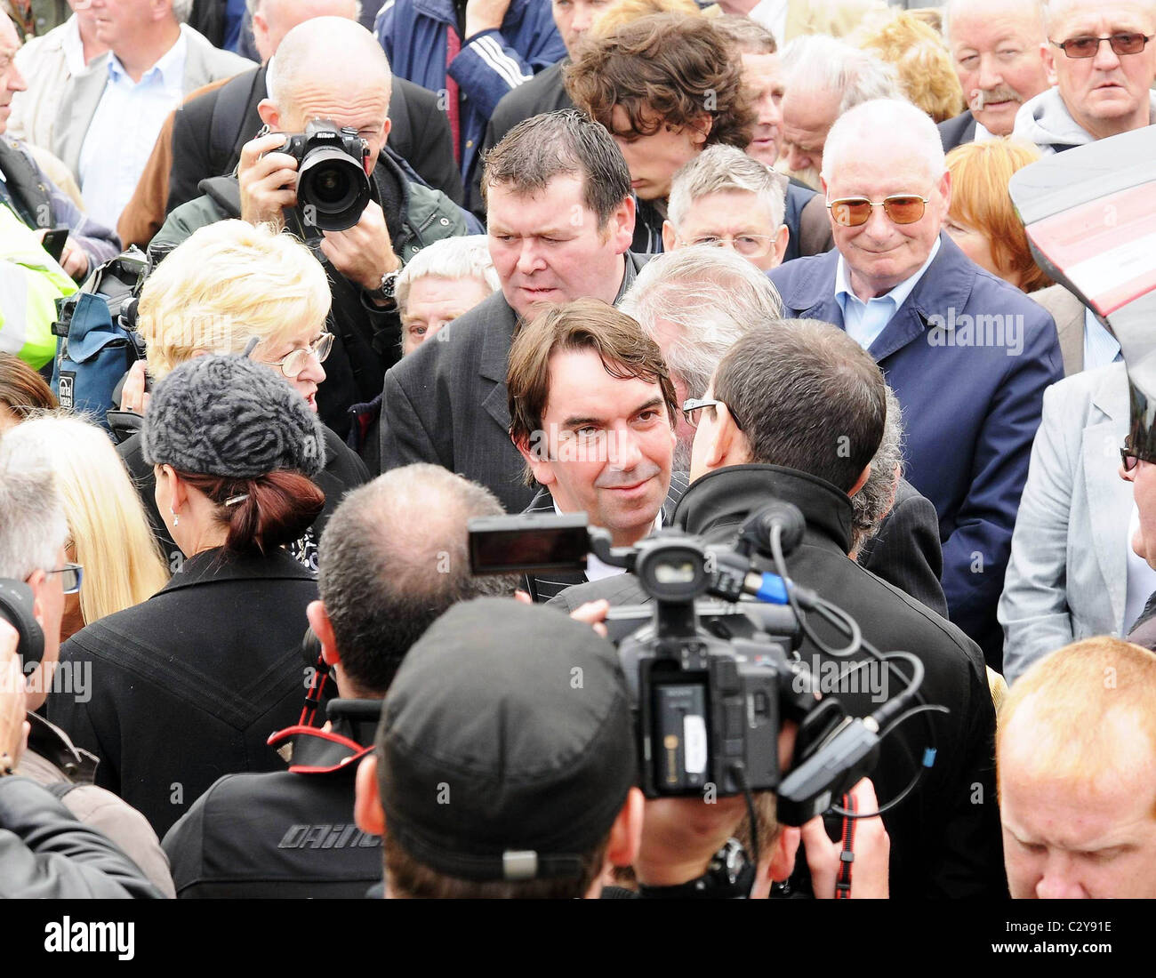 Phelim Drew surrounded by press for his father's funeral, 'The ...