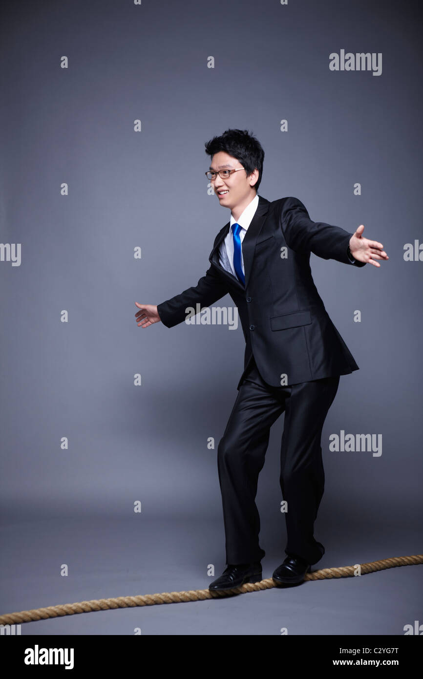 businessman posing walking on rope Stock Photo - Alamy