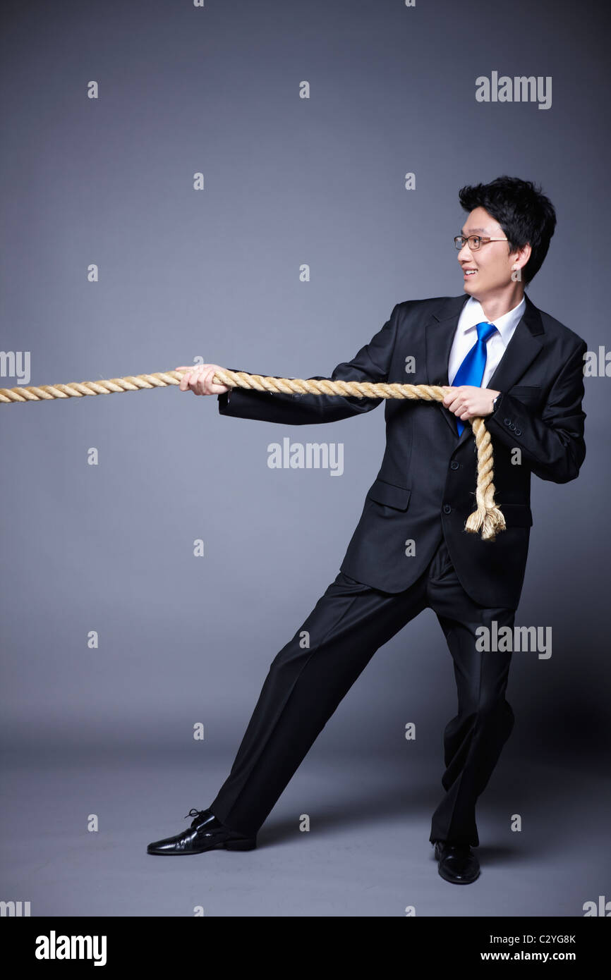 businessman posing pull the rope Stock Photo - Alamy