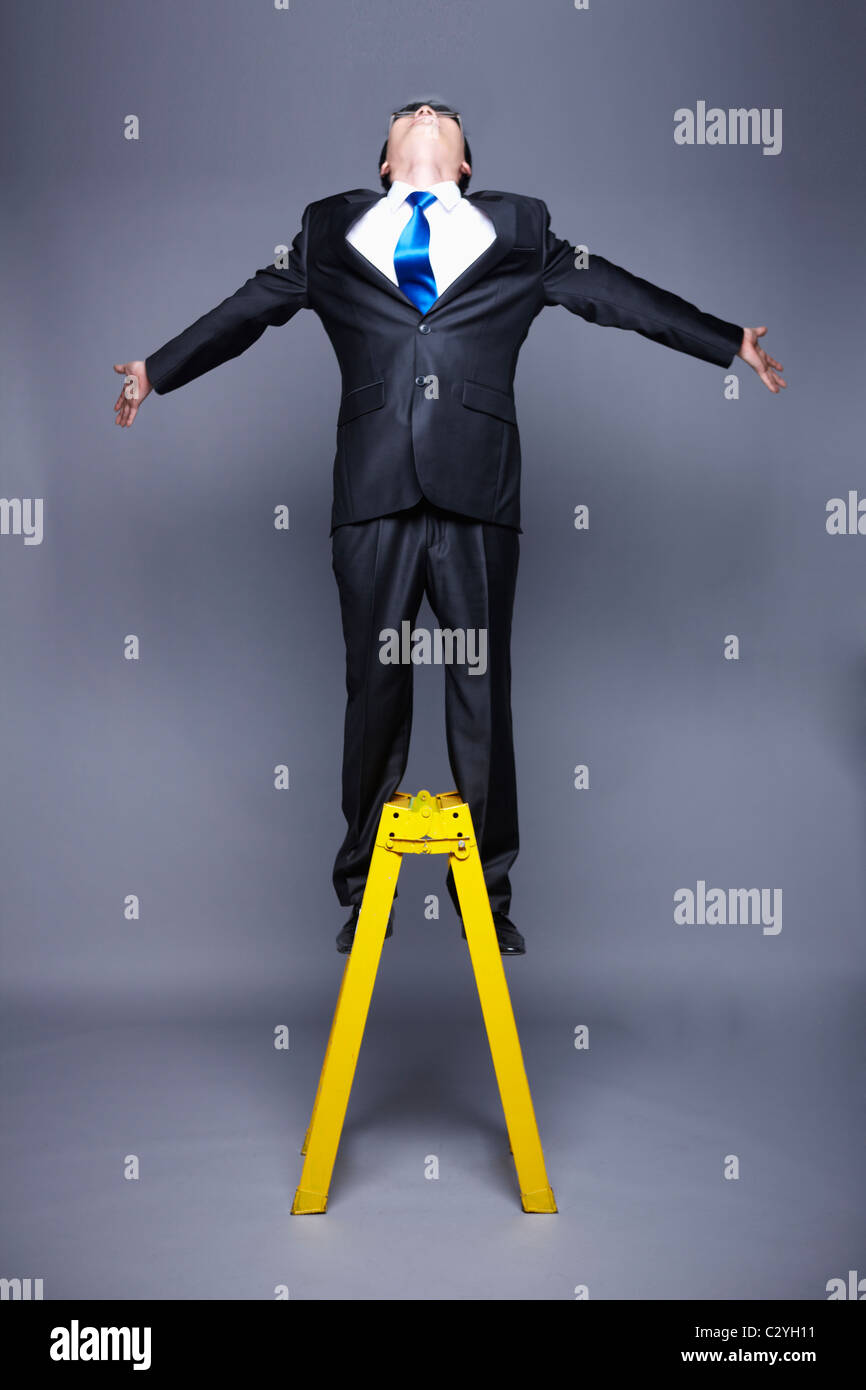 businessman standing on ladder bending his upper body backwards Stock ...