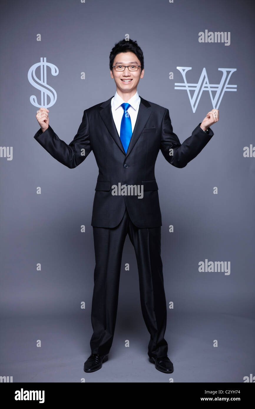 businessman holding dollar and Korean Won sign Stock Photo - Alamy