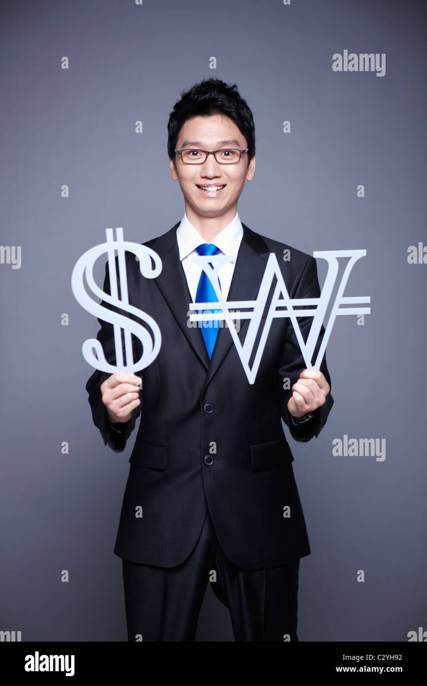 businessman holding dollar and Korean Won sign Stock Photo - Alamy