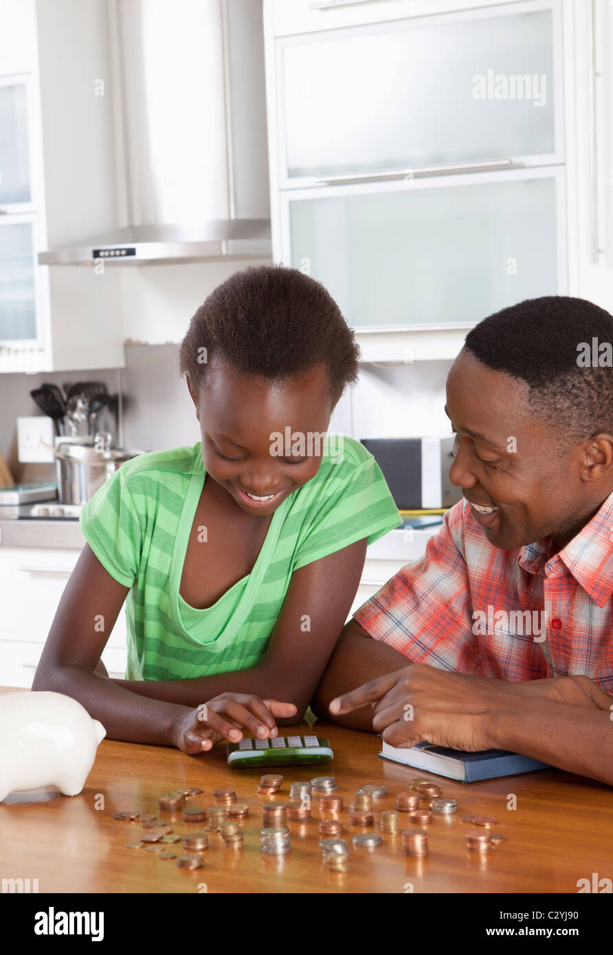 Father helping daughter count money, Johannesburg, South Africa Stock ...