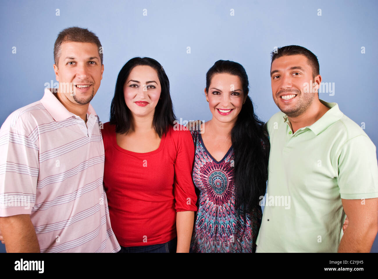 Happy two couples standing in a line closer to each other and smiling ...