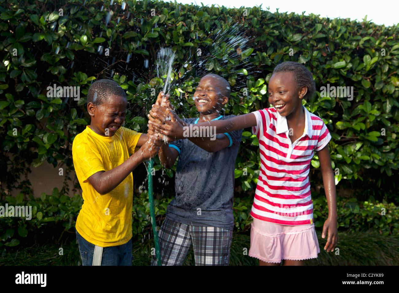 Children spraying each other with water hose, Johannesburg, South ...