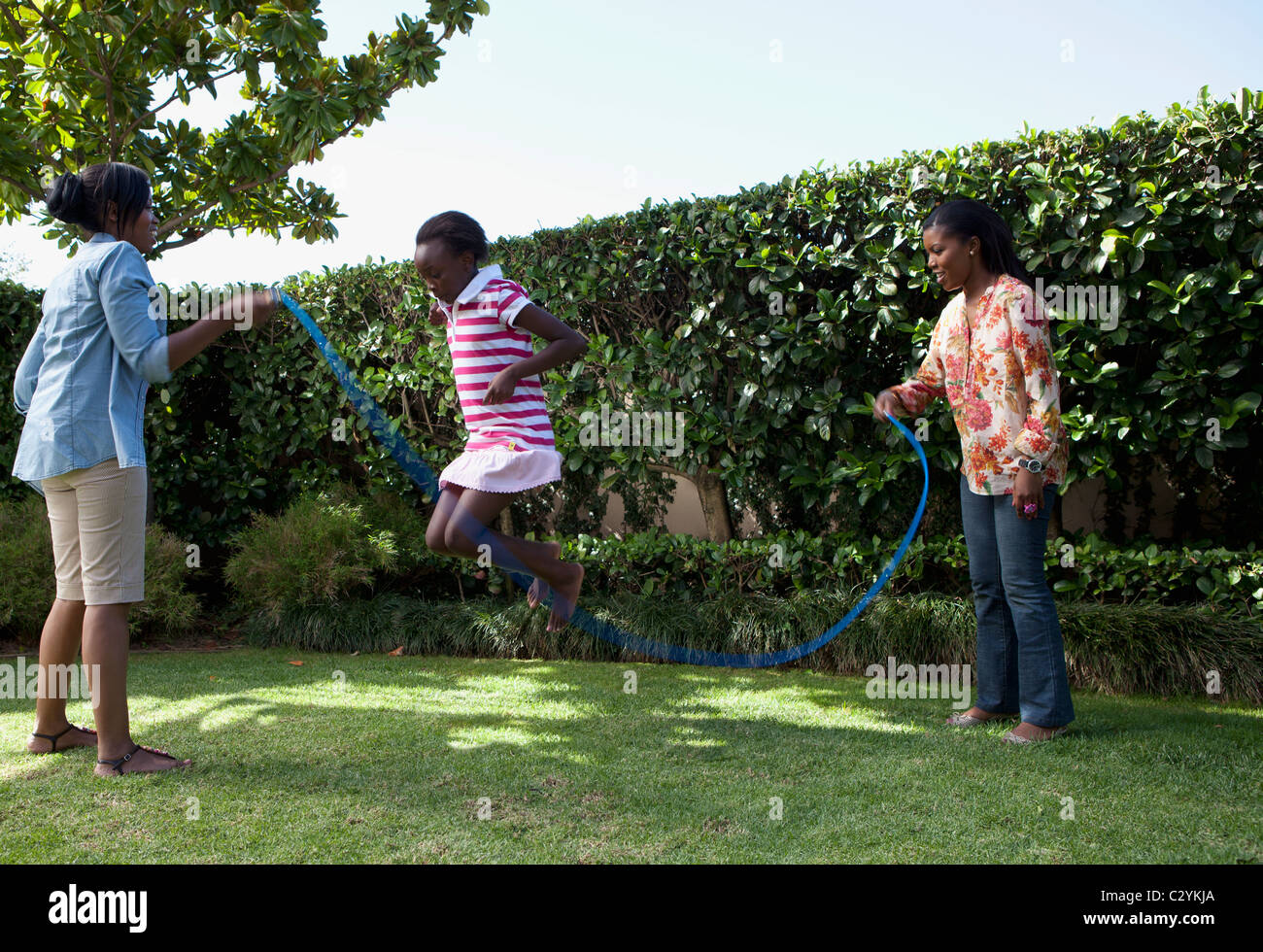 Children playing jump rope in garden, Johannesburg, South Africa Stock ...