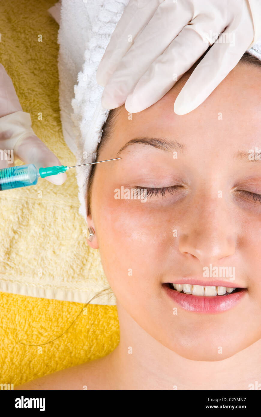 Close up of smiling woman getting a injection with botox in eyebrow ...