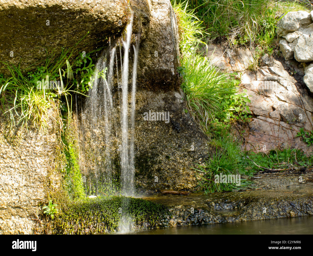waterfall between rocks with vegetation on the sides Stock Photo - Alamy