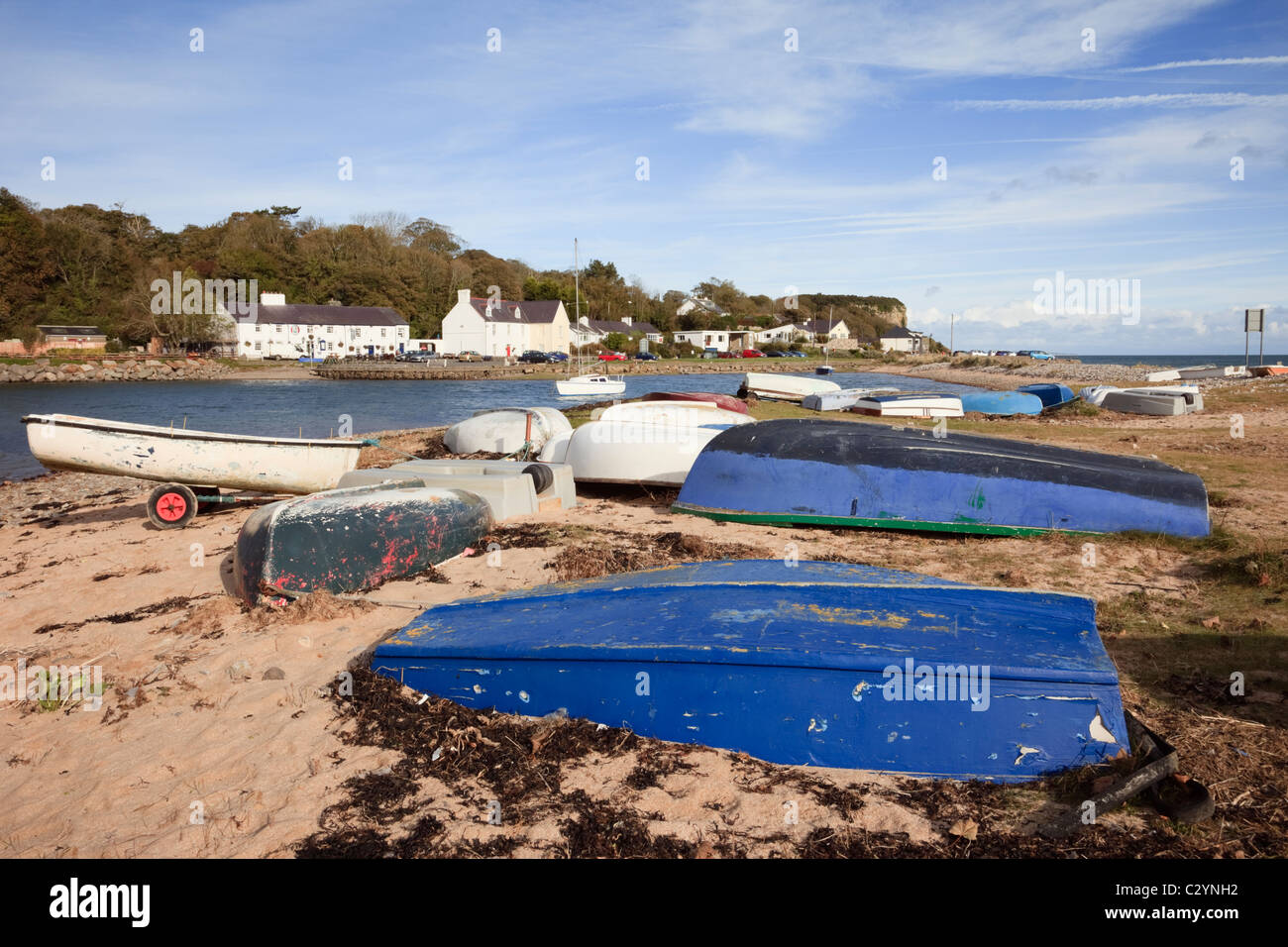 Upturned boats with view to The Ship Inn and village across small ...