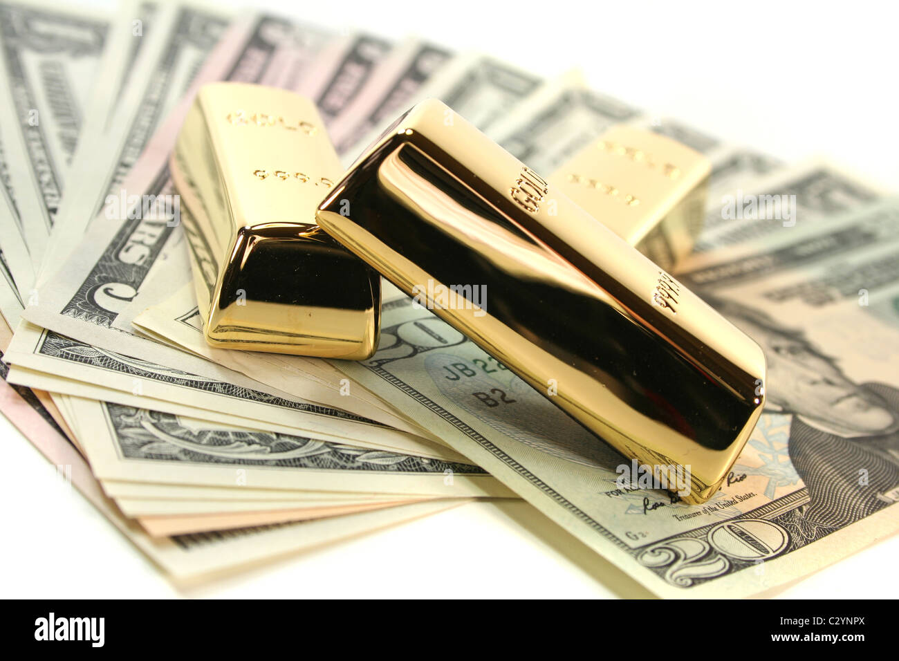 three large gold bars on many dollar bills Stock Photo - Alamy