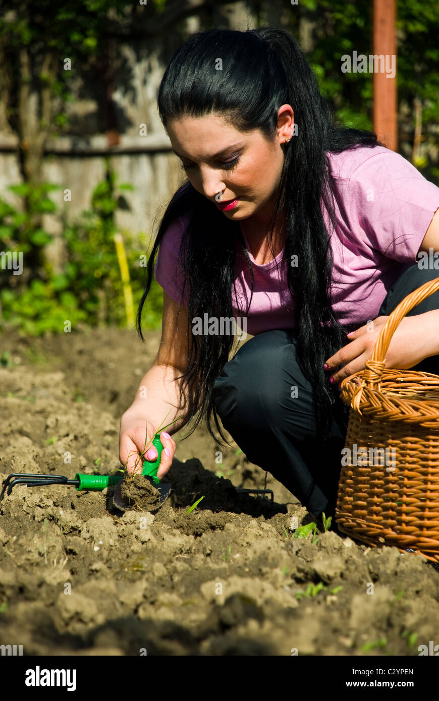 Beautiful woman using tools for gardening and working her soil Stock ...