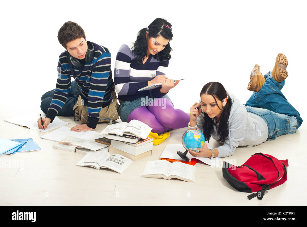 Three students sitting on wooden floor having a conversation and ...
