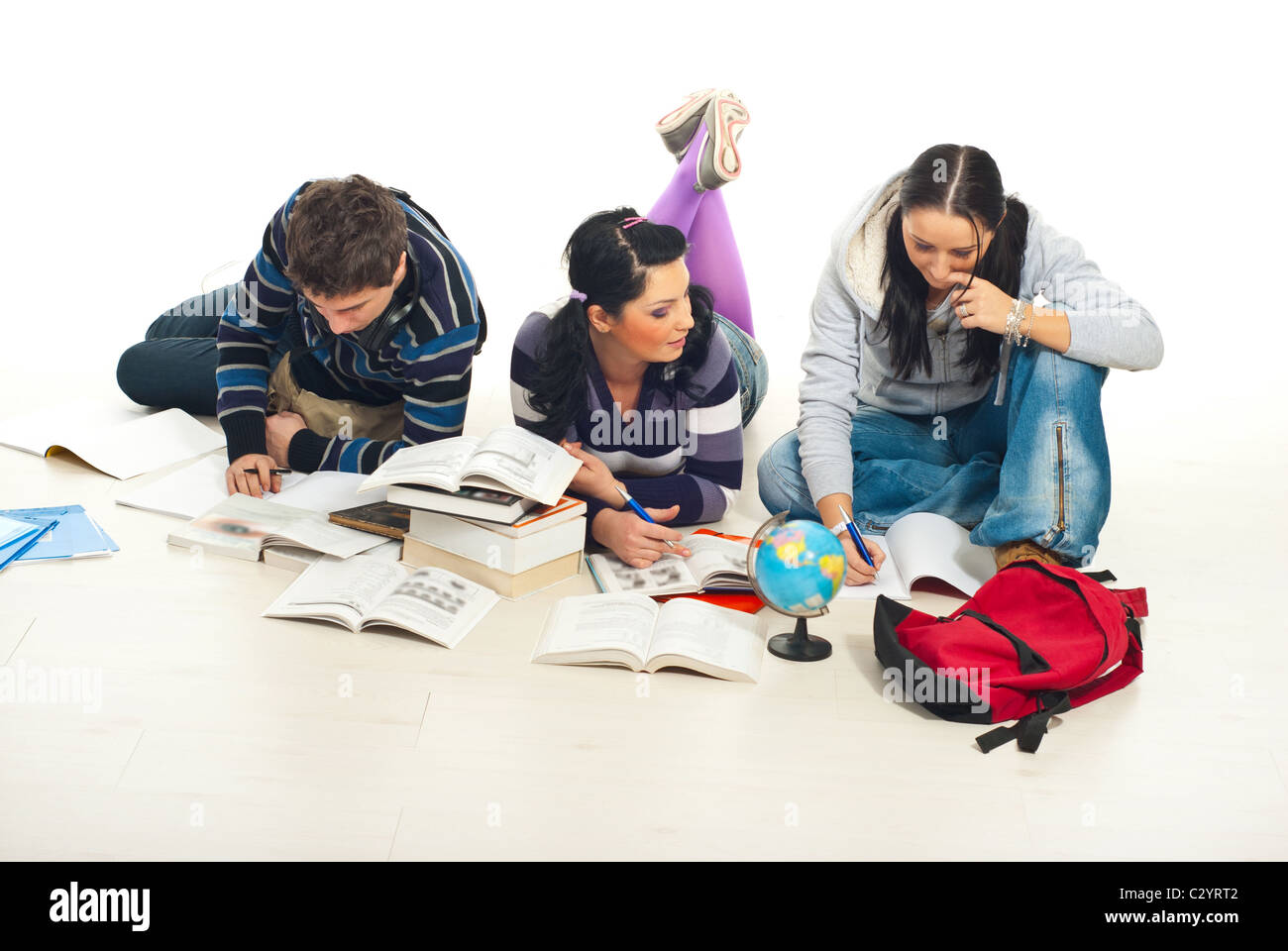 Three student lying down on wooden floor and make their homework Stock ...