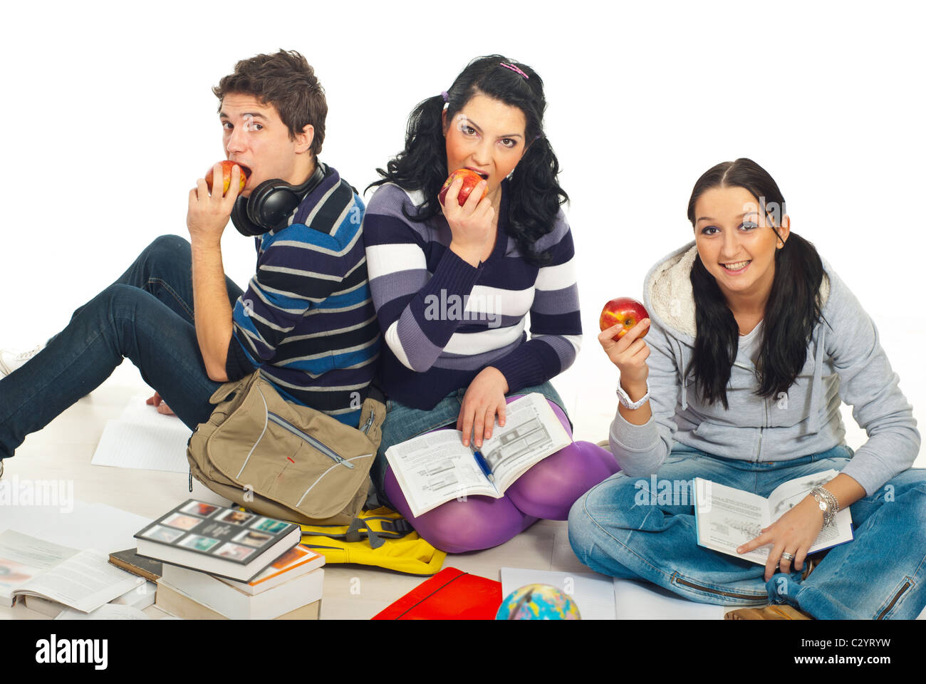 Happy healthy students eating apples and sitting on wooden floor and ...