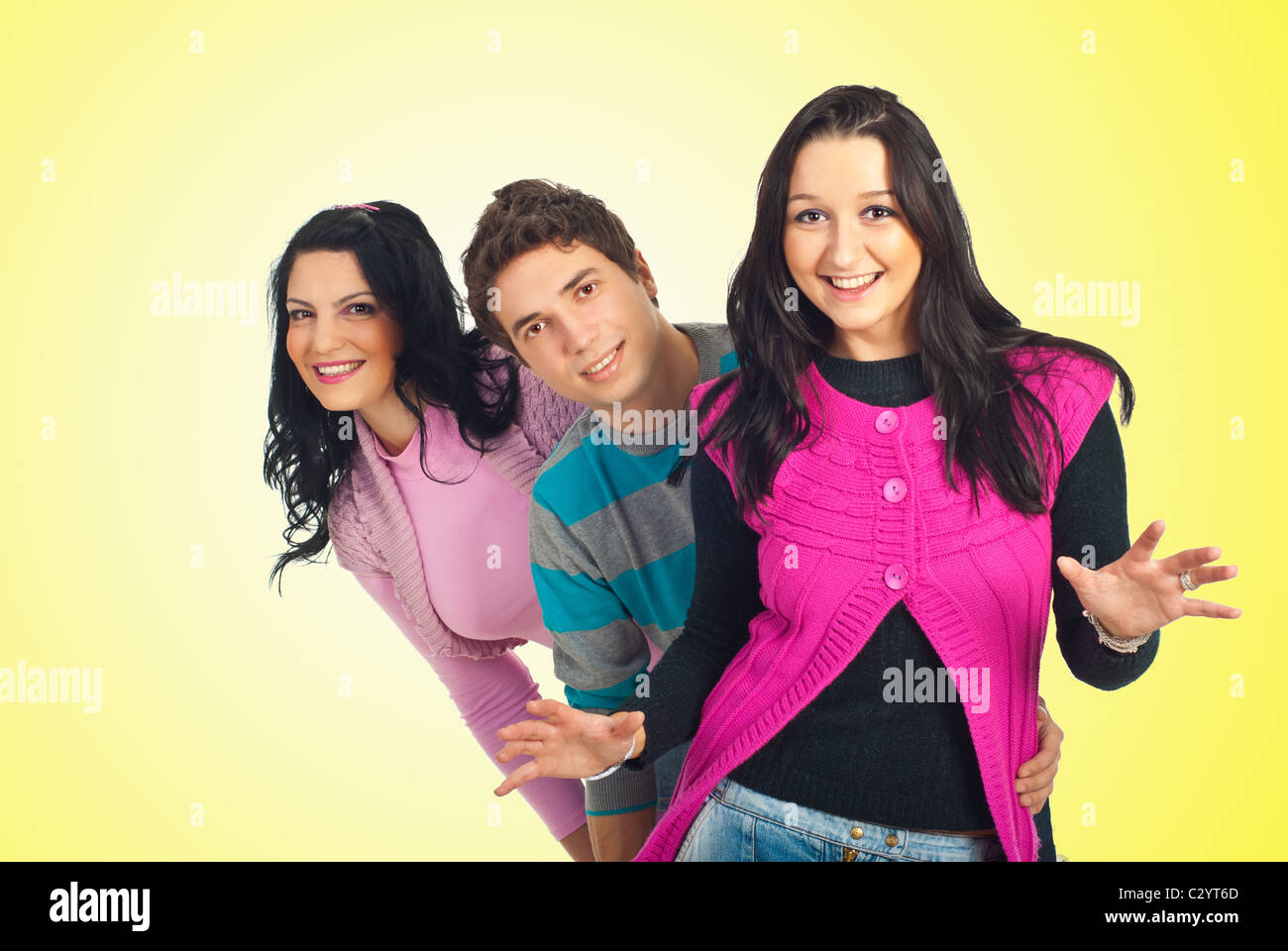 Cheerful three friends smiling over yellow background Stock Photo - Alamy