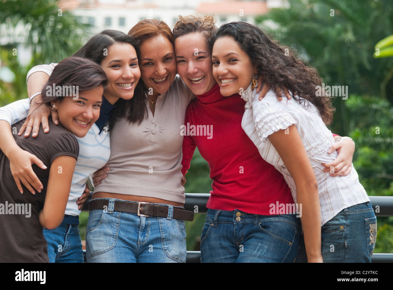 Smiling Hispanic women hugging Stock Photo - Alamy