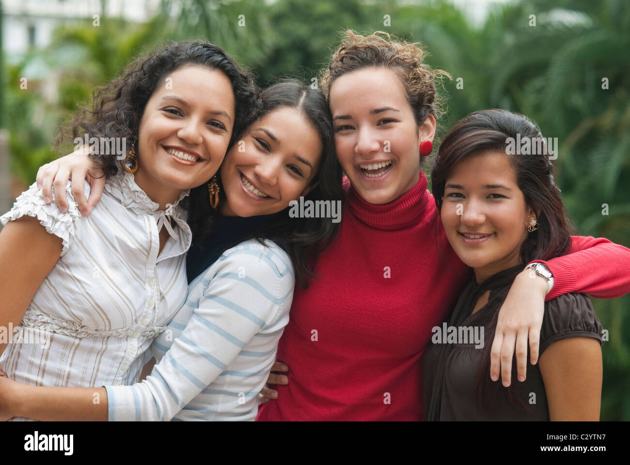 Smiling Hispanic friends hugging Stock Photo - Alamy