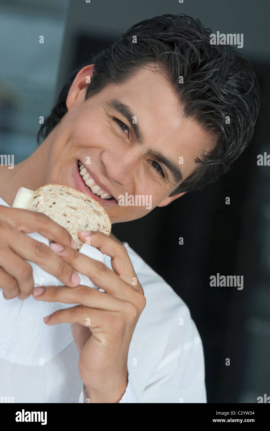 Hispanic man eating sandwich Stock Photo - Alamy