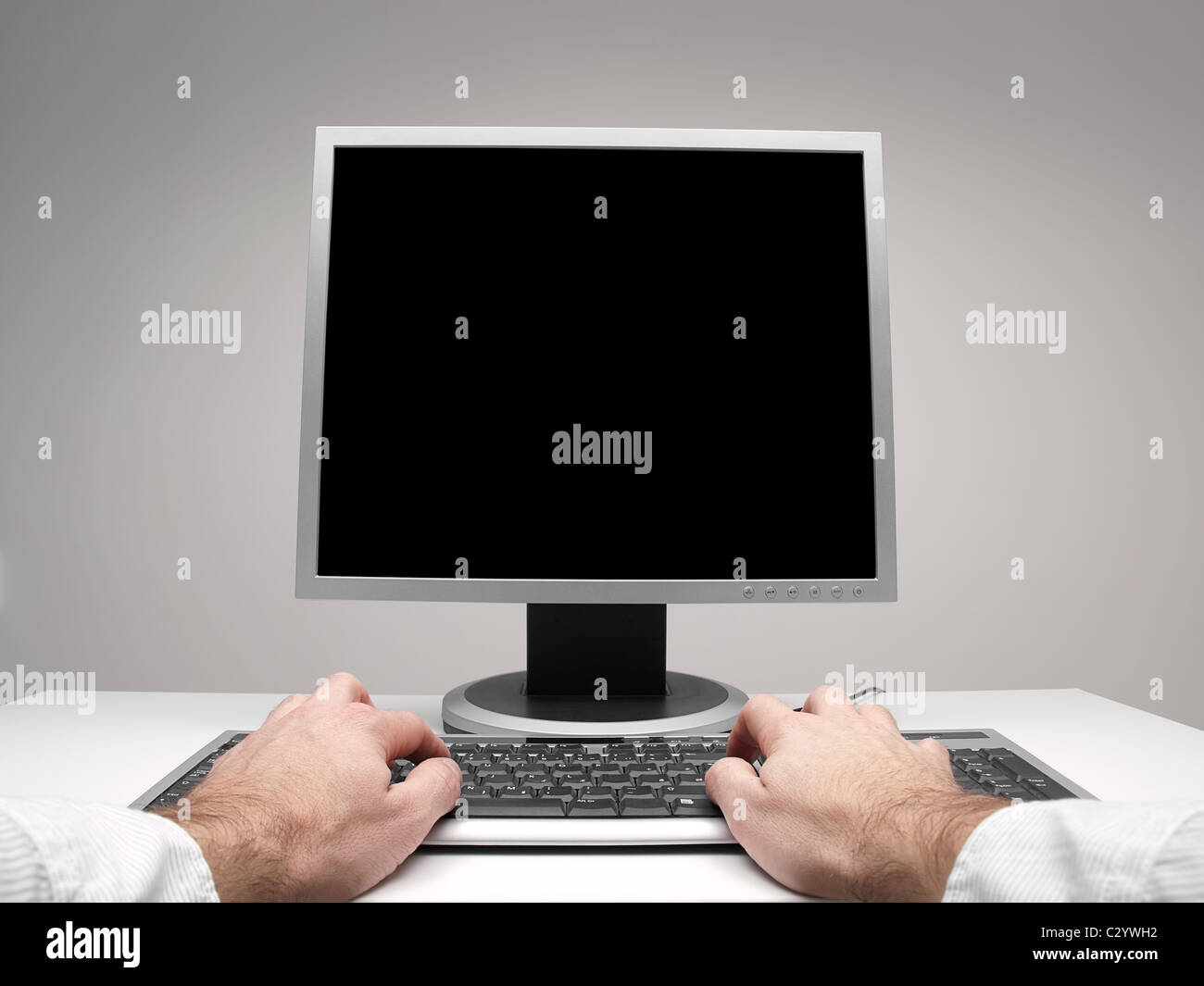Male hands on the desktop computer keyboard with monitor black screen ...