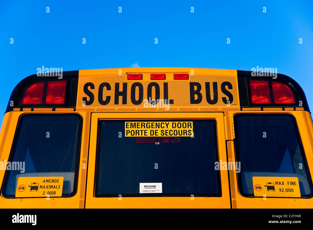 The top half of the back of a yellow School Bus displaying the words ...