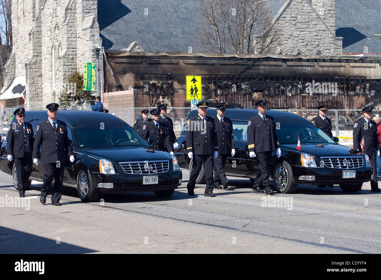 The funeral procession for Ken Rae and Raymond Walter pass the burned ...