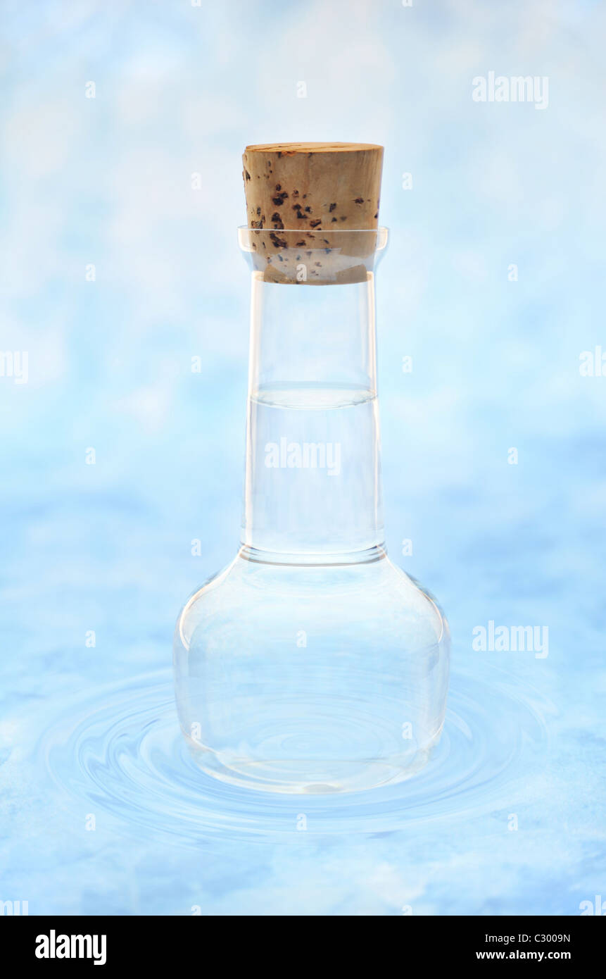 Bottle of clean water in water ripples over colored background Stock ...