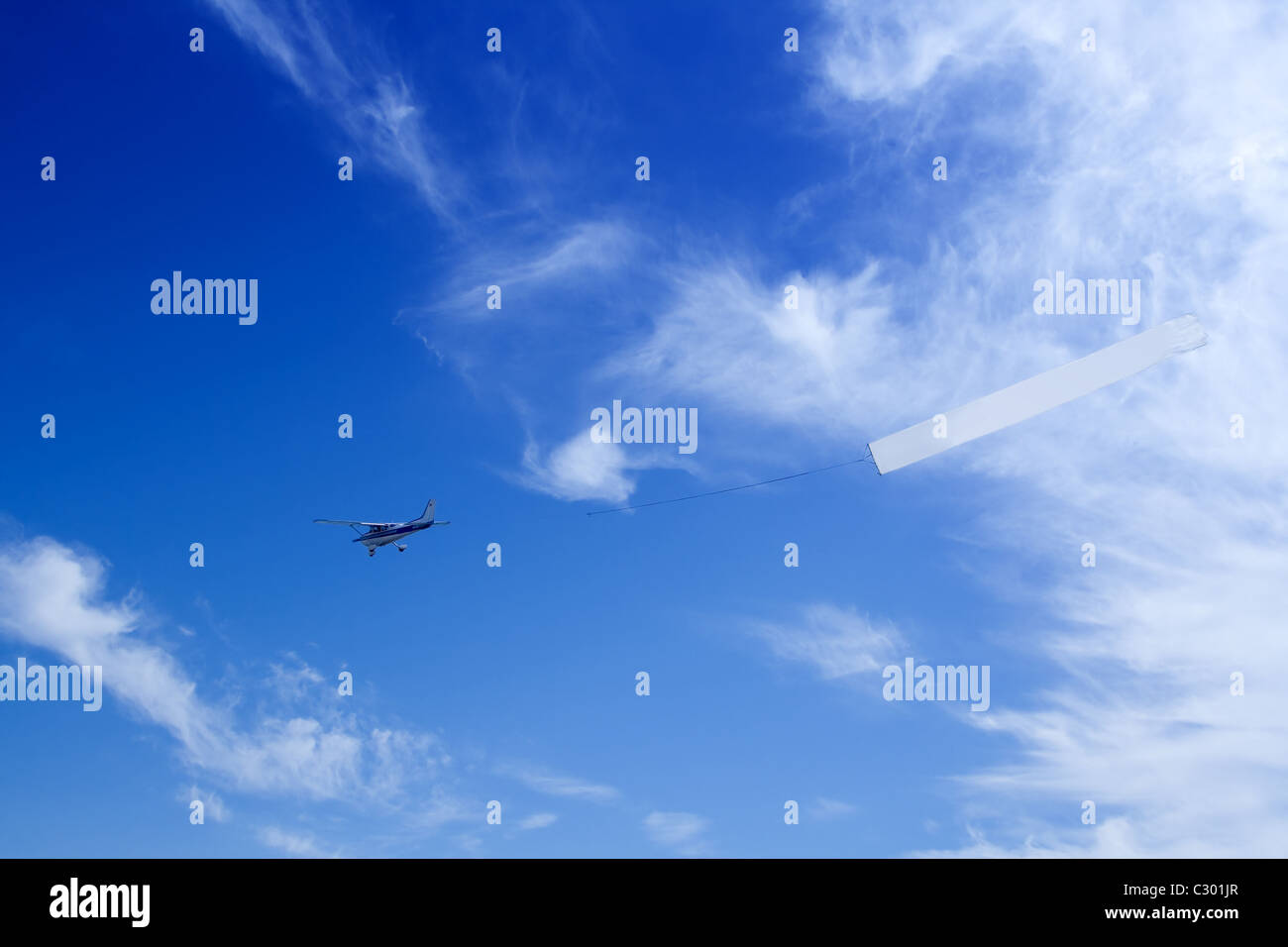 Small airplane pulling a blank sign for advertisements Stock Photo - Alamy