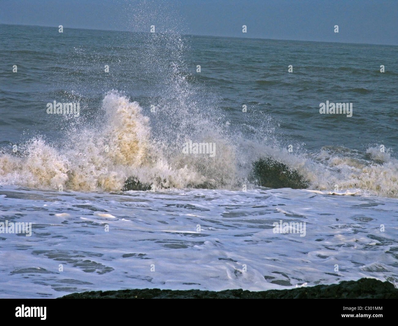 A huge wave splashing on the rocks where the three seas mingle ...