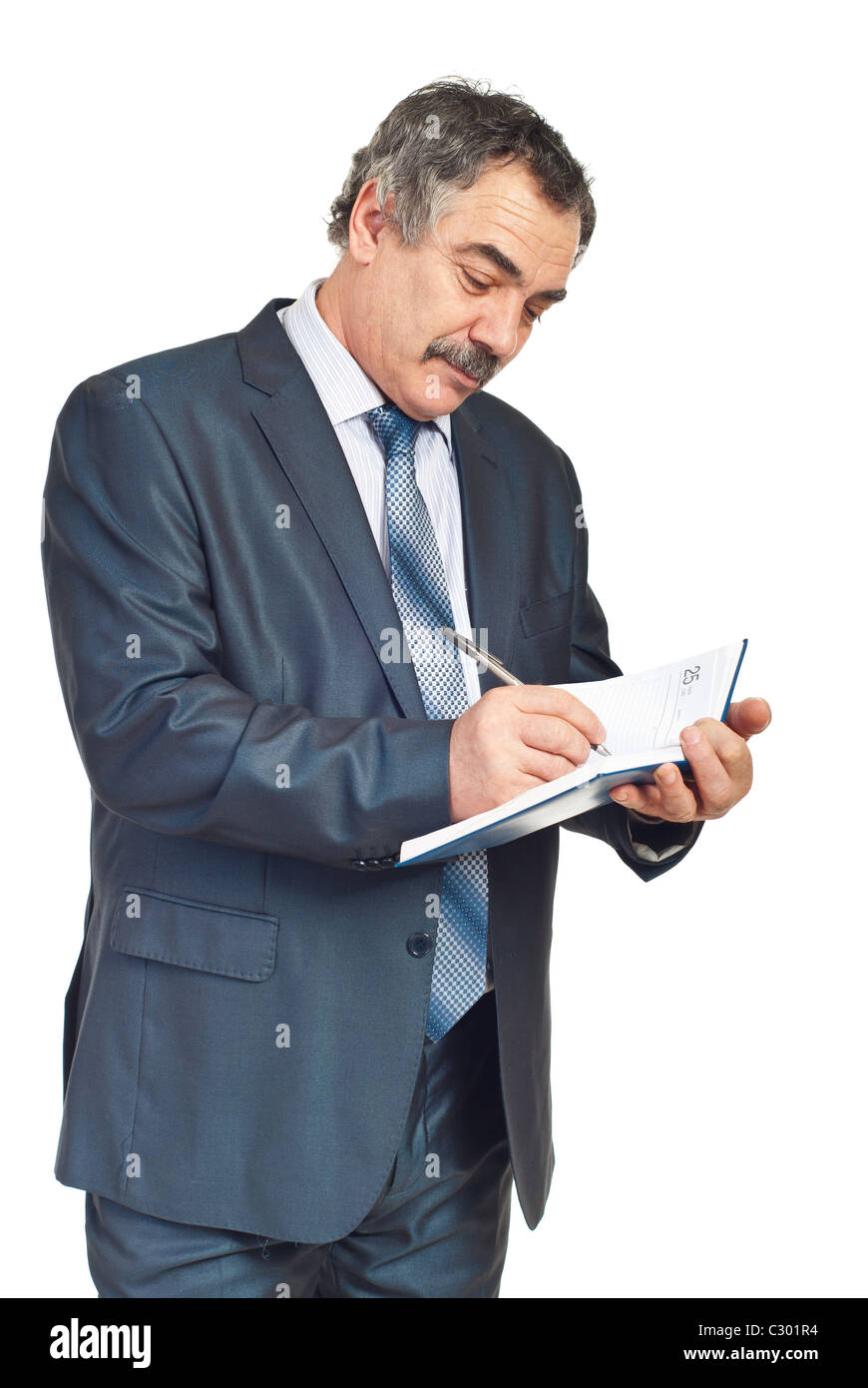 Smiling mature executive man taking notes in his personal agenda ...