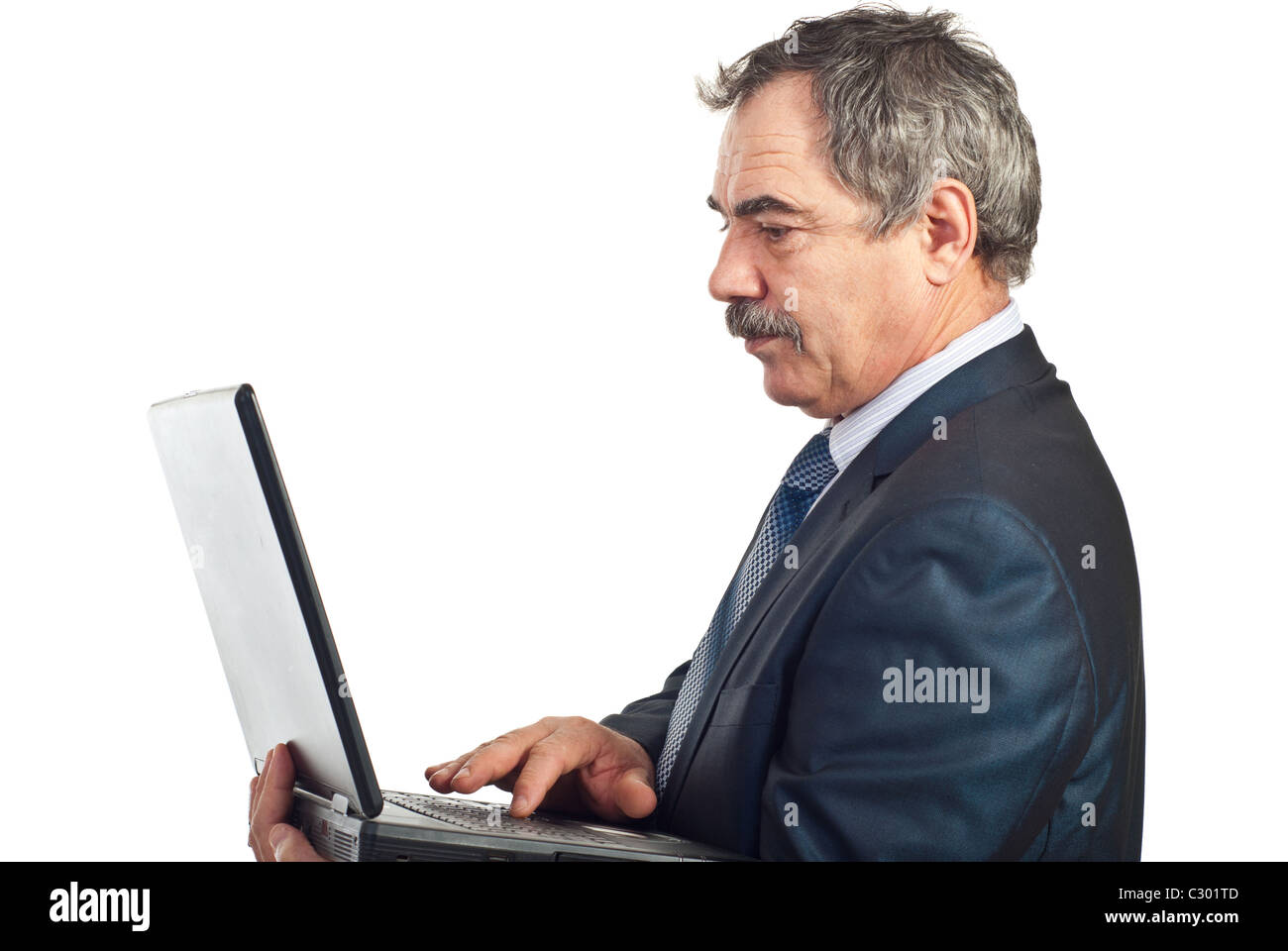 Profile of mature serious business man typing on laptop isolated on ...