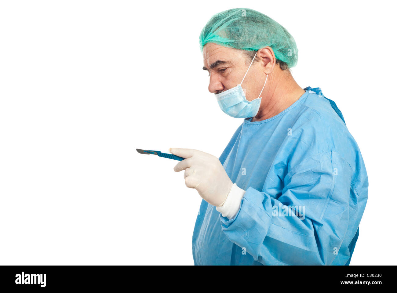 Mature surgeon man standing in profile and holding scalpel isolated on ...