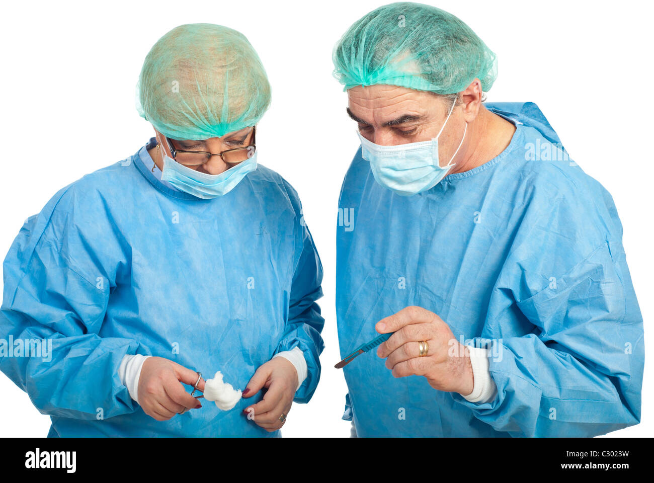 Two middle aged surgeons in surgery holding scalpel and forceps ...