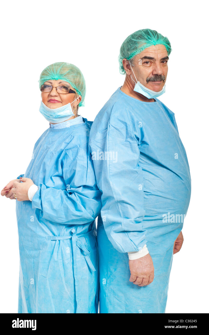 Team of mature surgeons standing back to back and looking camera ...
