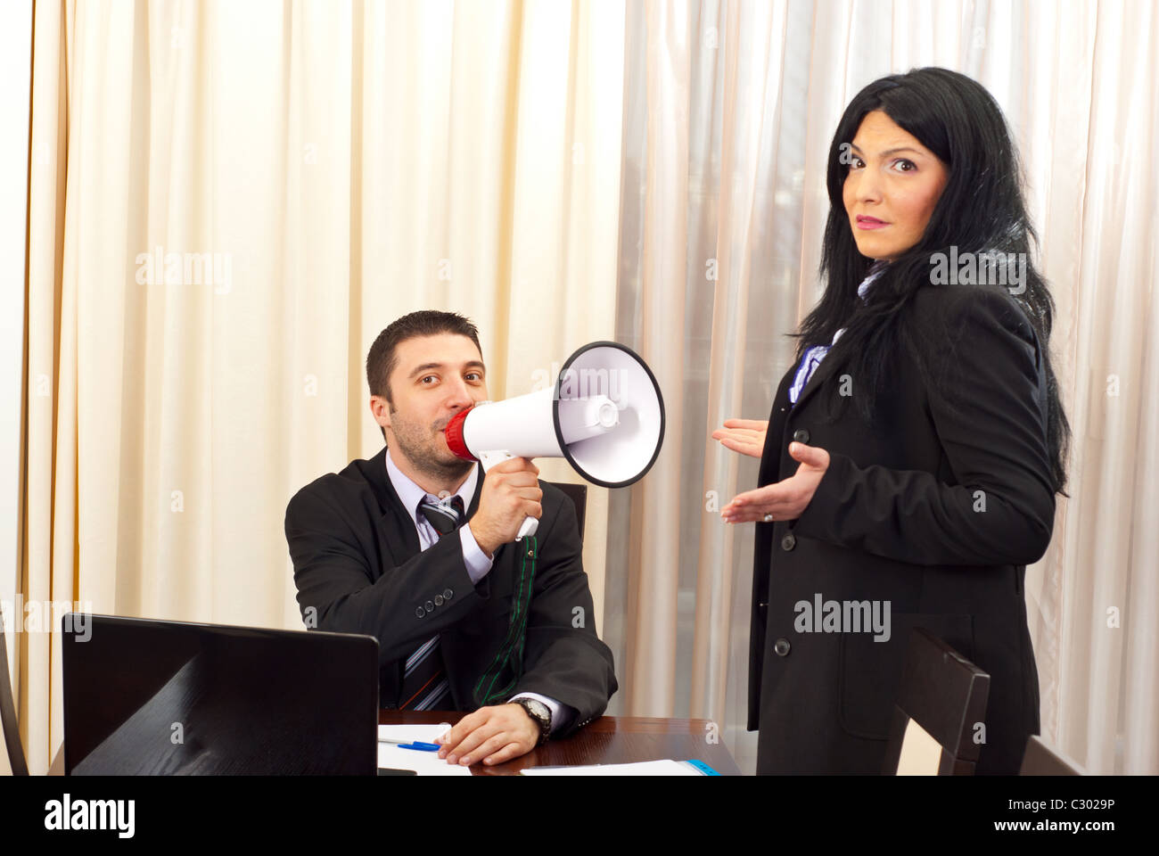 Two business people with megaphone in an office Stock Photo - Alamy