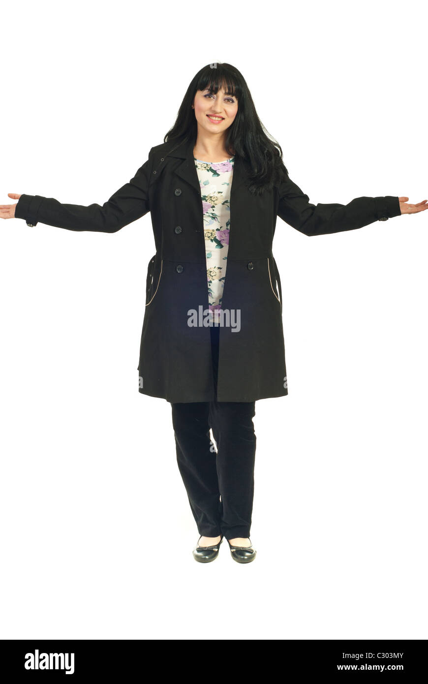 Full length of mid adult woman in black jacket standing with arms open ...