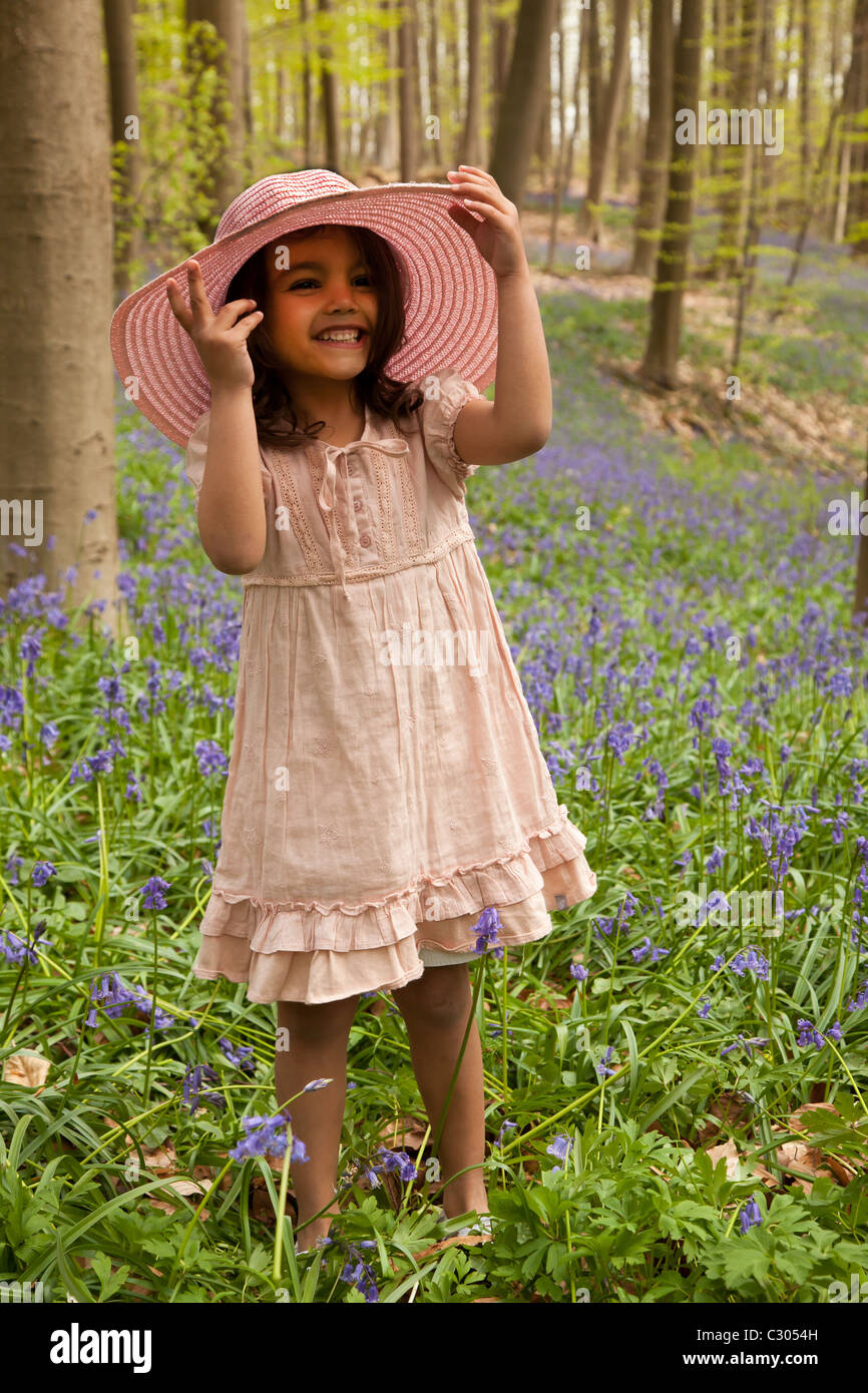 little girl in rose in the woods between the bluebells Stock Photo - Alamy
