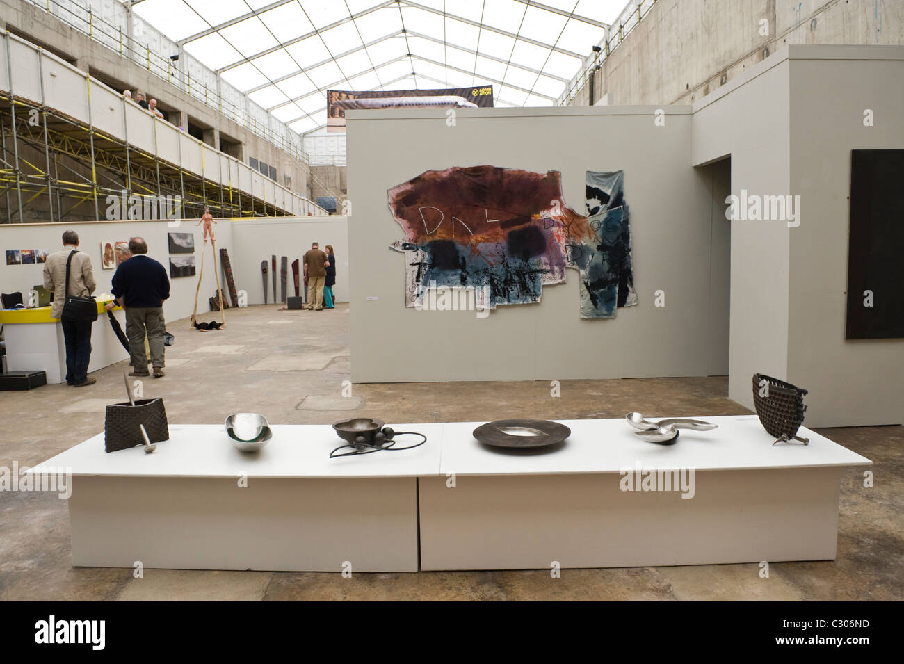 Visitors looking at art exhibition in former steel works industrial ...