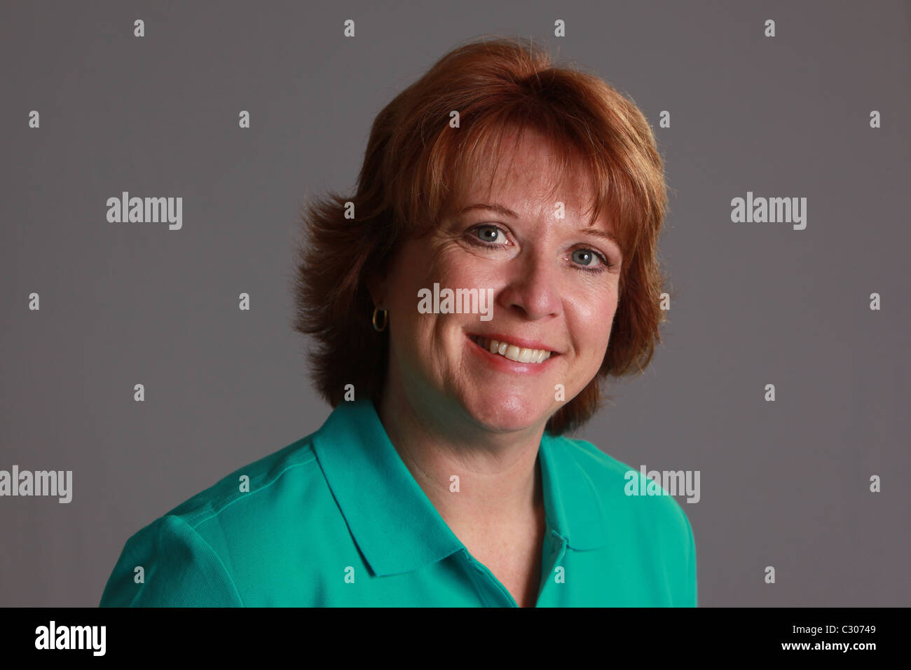 Attractive middle-aged American woman smiling, looking at camera, grey ...