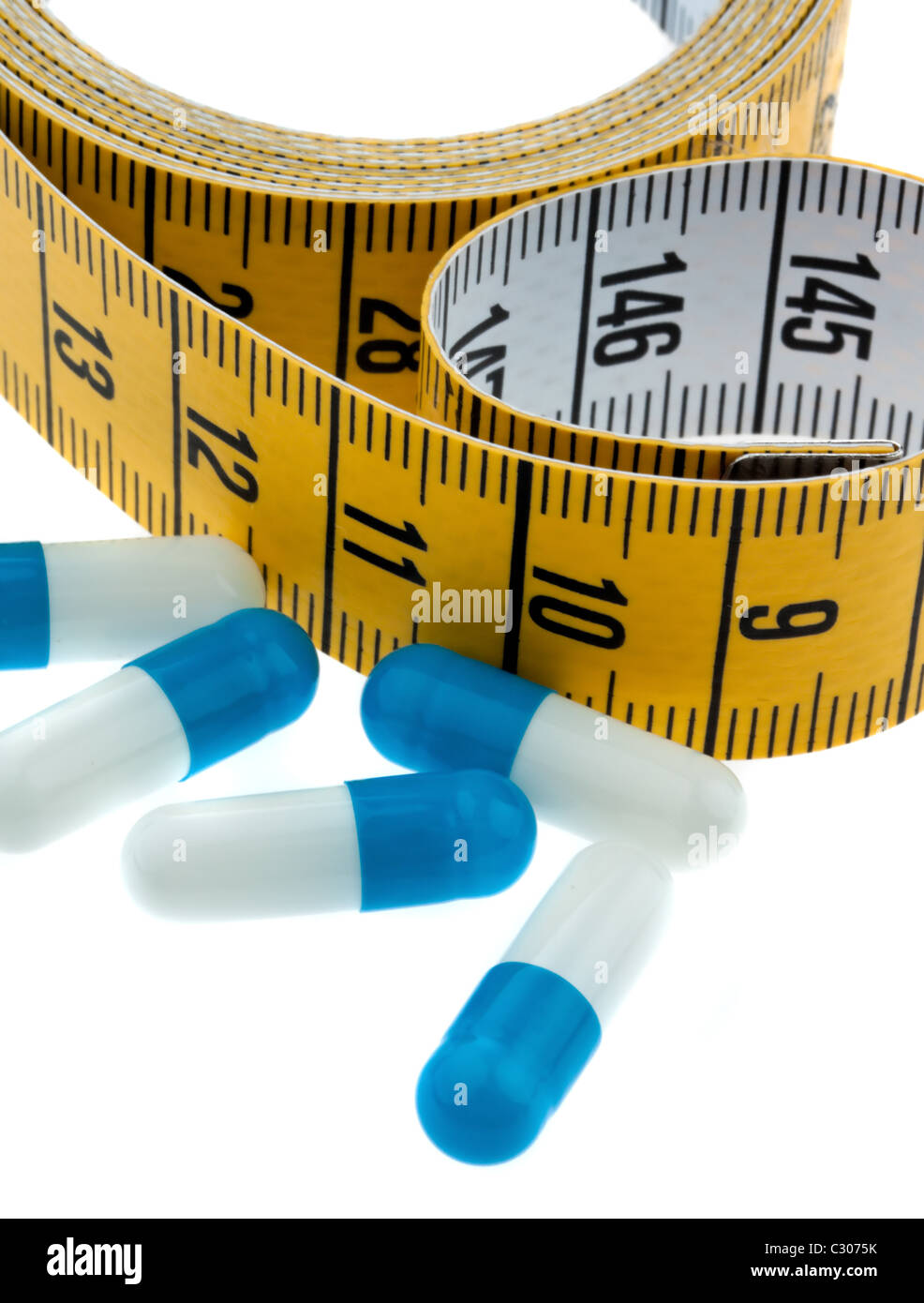 Measuring tape with tablets Stock Photo - Alamy