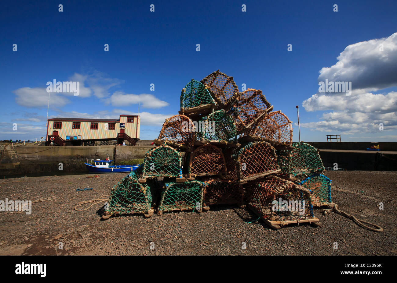 The lifeboat station and creel pots on the harbour wall at St. Abbs ...