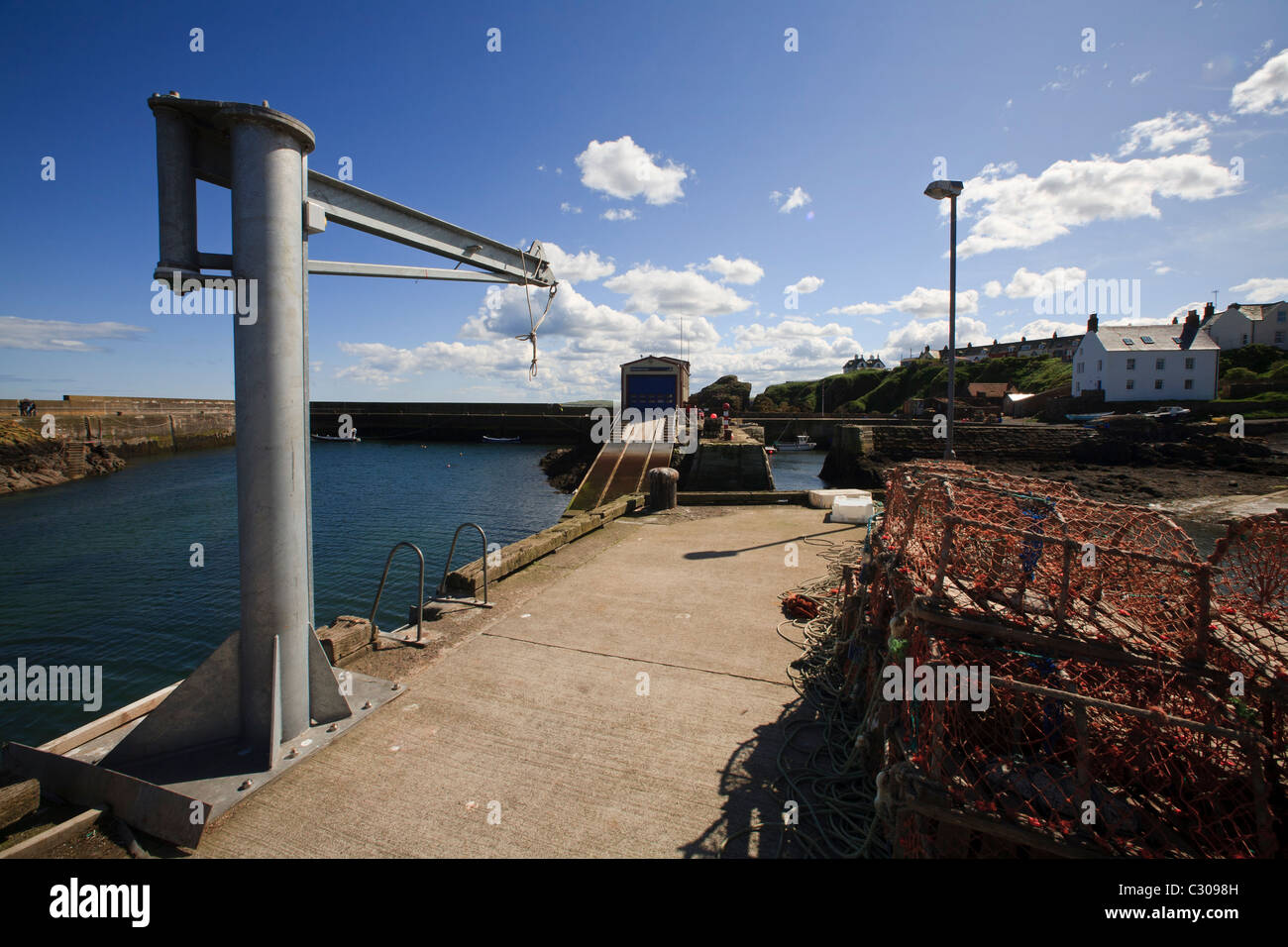 Creel pots and crane on the harbour wall at St. Abbs, Berwickshire ...