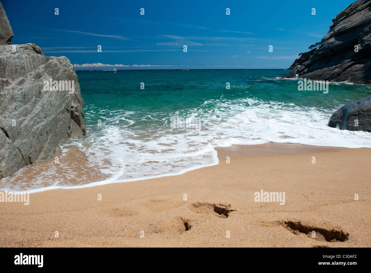 Lonely beach with waves and foot steps Stock Photo - Alamy