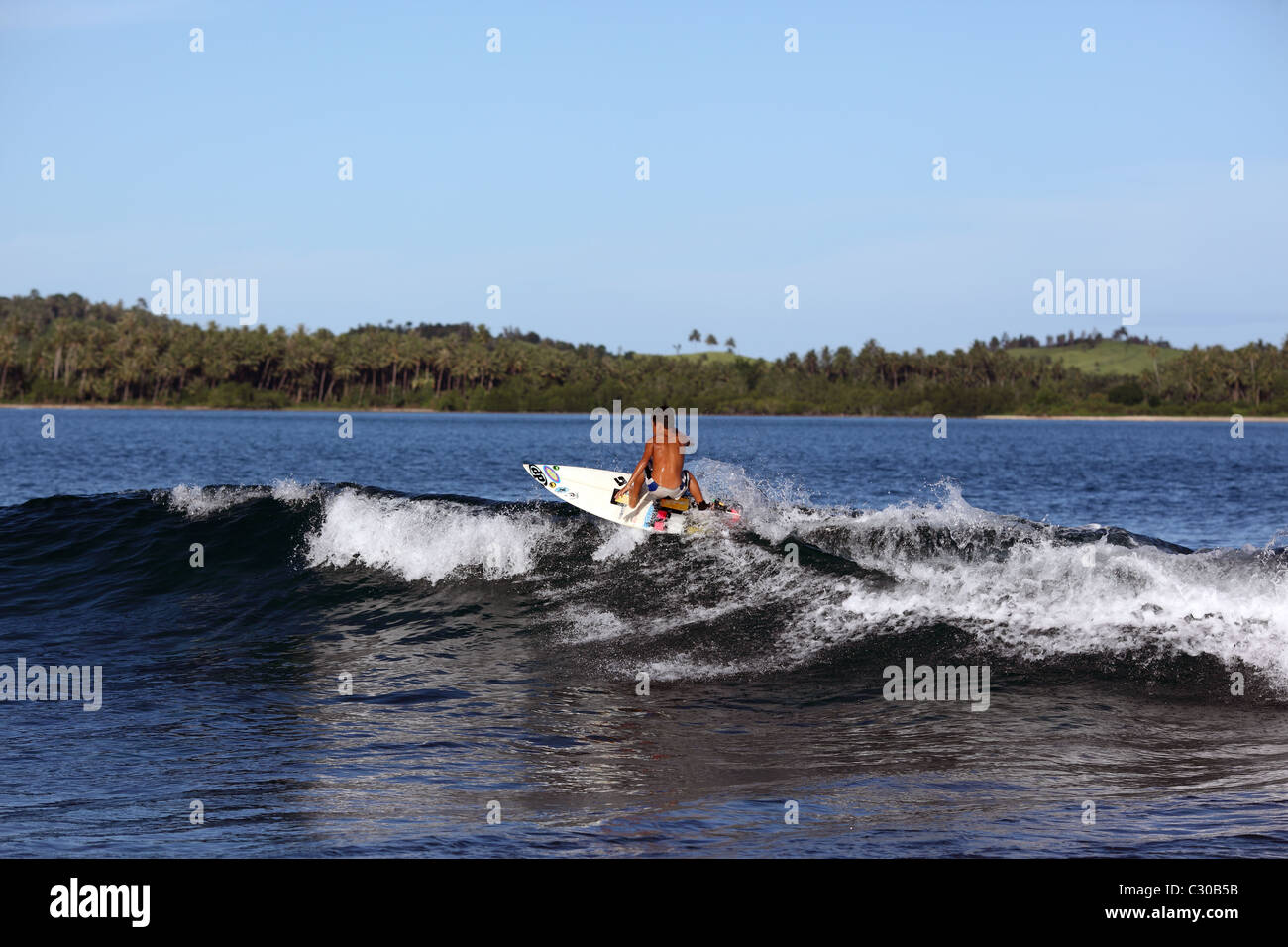 Young local surfing the inside point at Lagundri Bay on Nias Island ...
