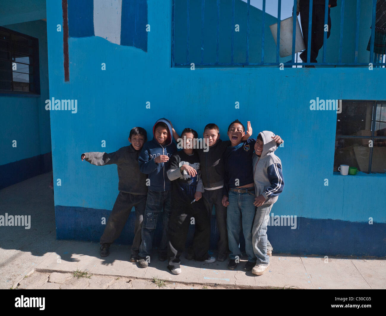 Guatemalan primary school boys make hand signals while joking around ...