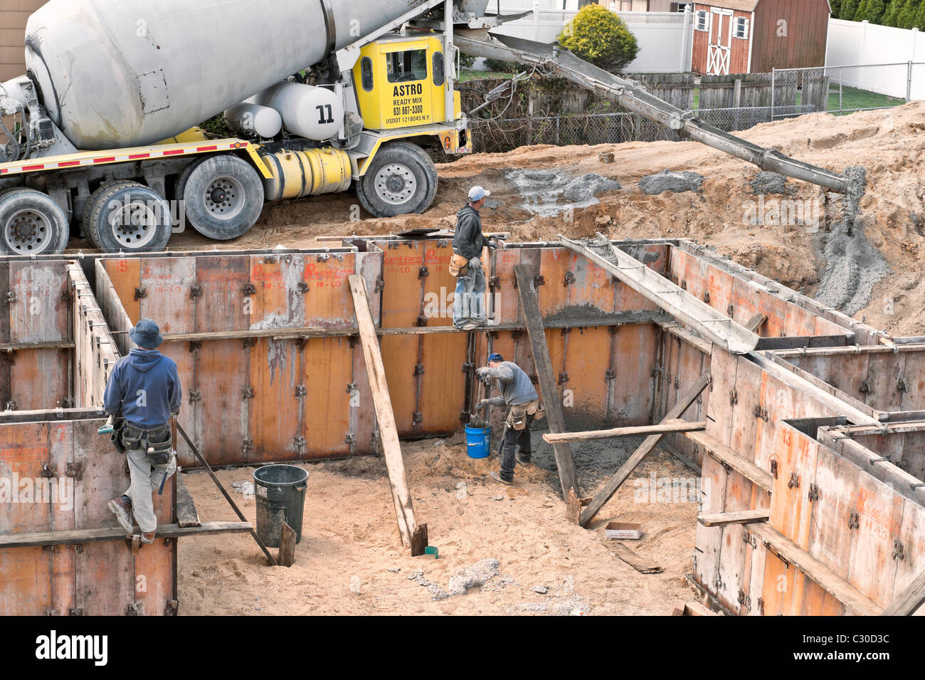 3 new home construction workers working on foundation of new home ...