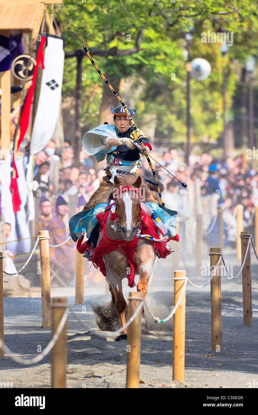 An Archer in Ancient Samurai Costume Prepares to shoot an arrow during ...