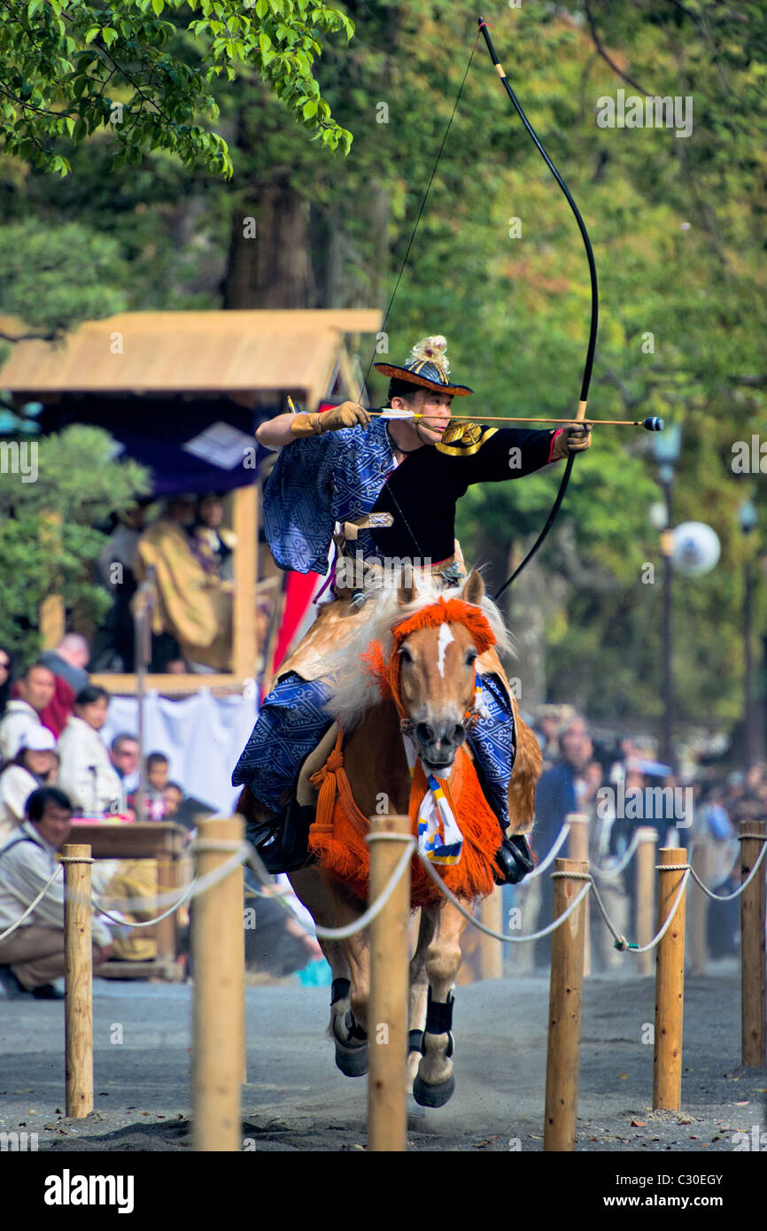 An Archer in Ancient Samurai Costume Prepares to shoot an arrow during ...